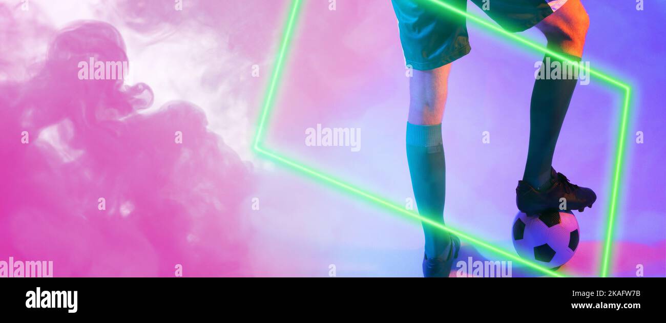 Low section of caucasian male player with leg on ball over illuminated ...