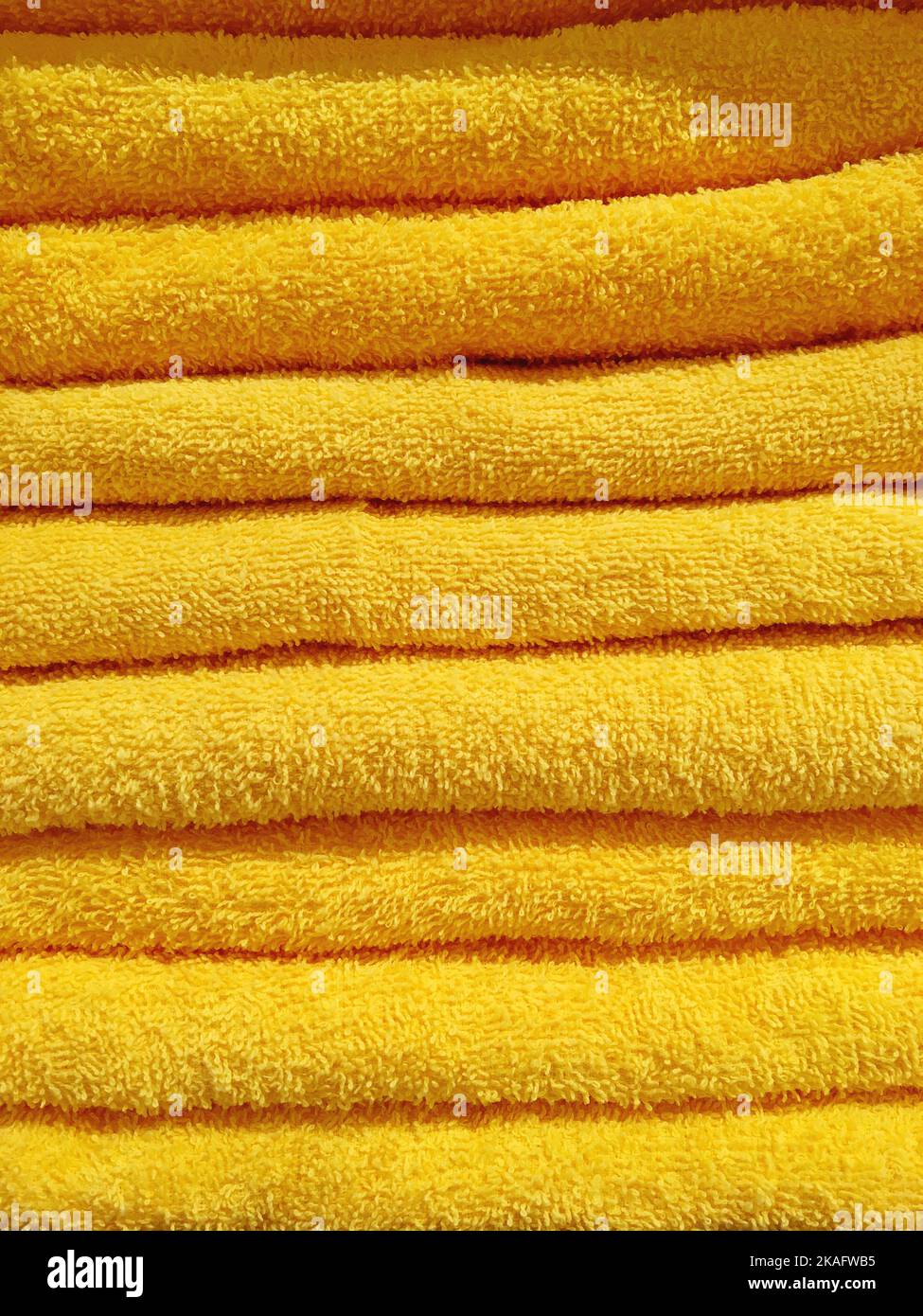 Stack of yellow terry towels. Pile of textile bath accessories Stock ...