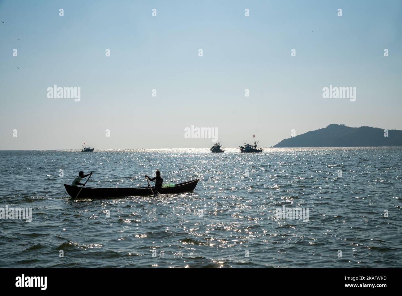 Fishing rowboat and fish ships (motorized) in the distance. Very ...