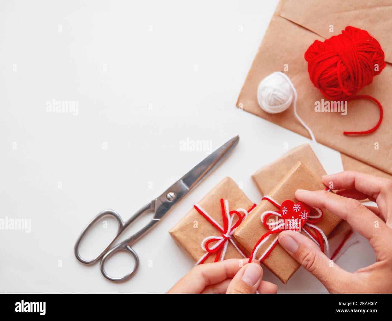 DIY presents wrapped in craft paper. Gifts tied with white and red ...