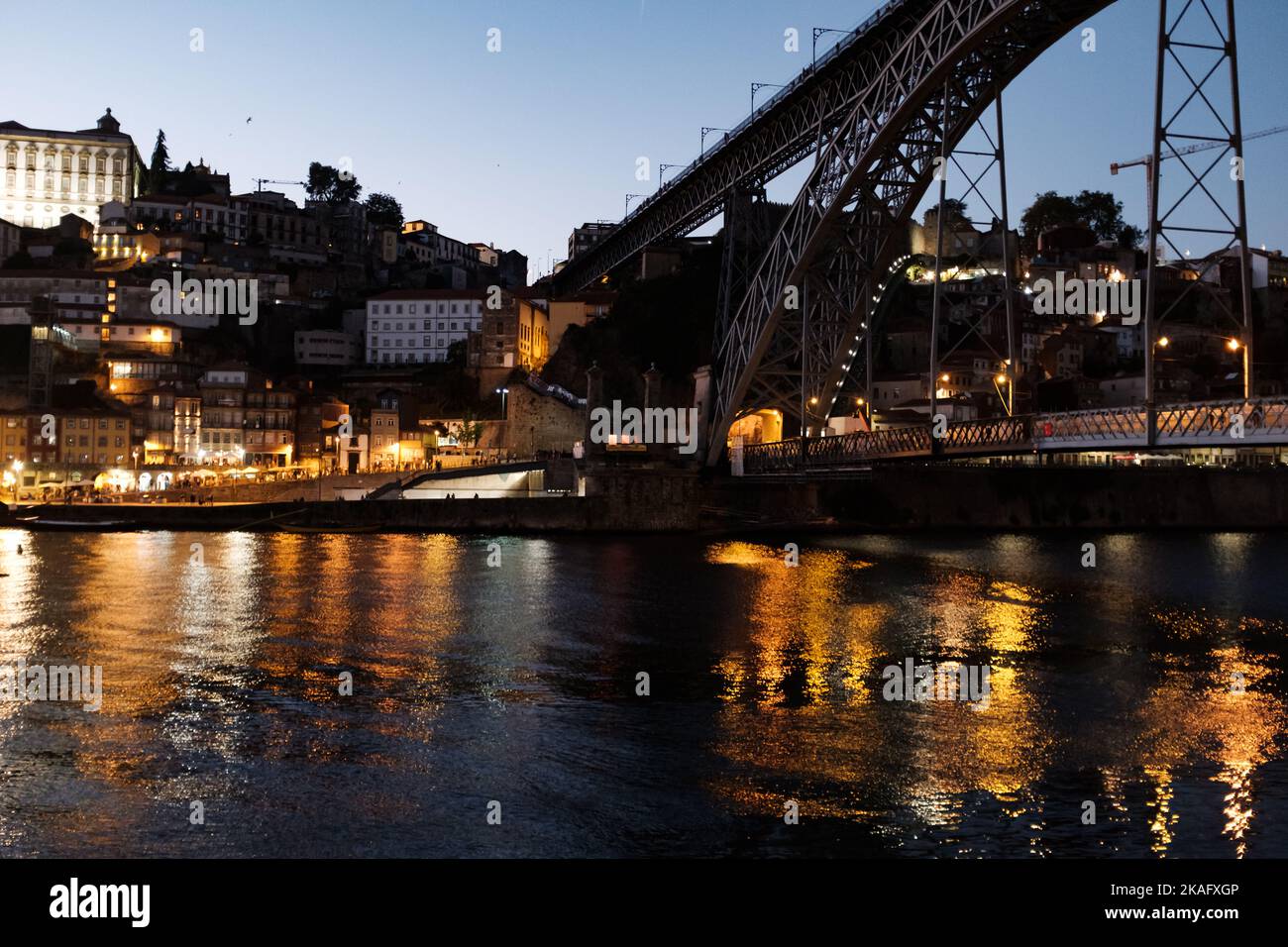 Dom Luis bridge in Oporto at night with quiet waters in Douro River and ...
