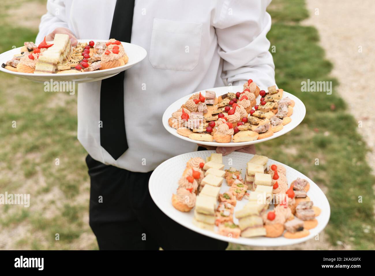 A waiter serves the small appetizers at the wedding Stock Photo - Alamy