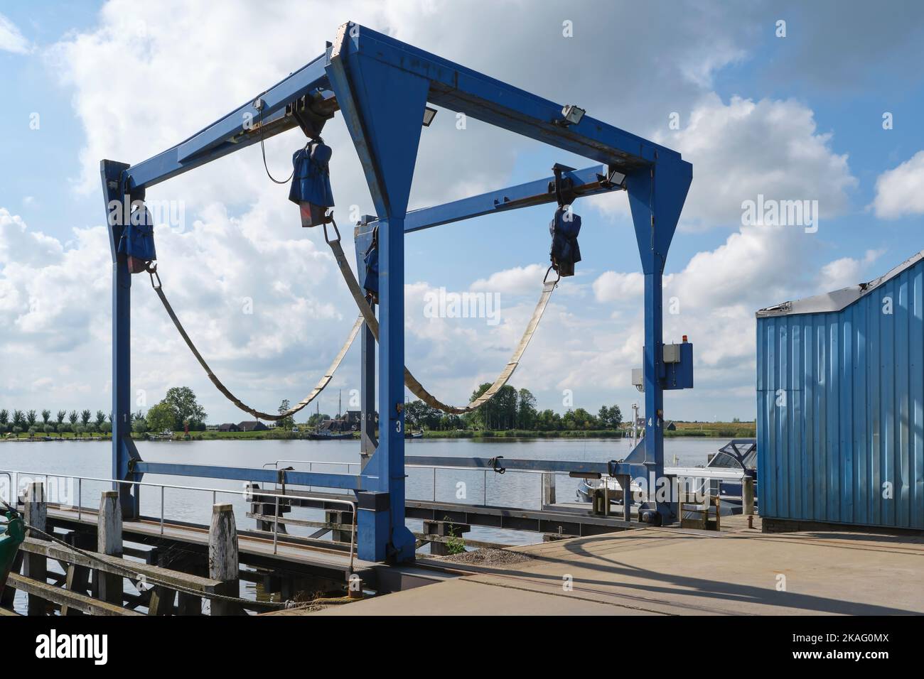 Empty boat travel lift in harbor under a blue sky with large clouds ...