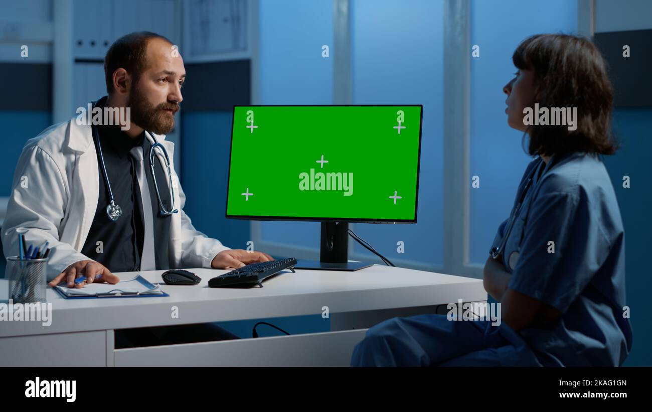 Physician and assistant discussing patient report planning health care ...