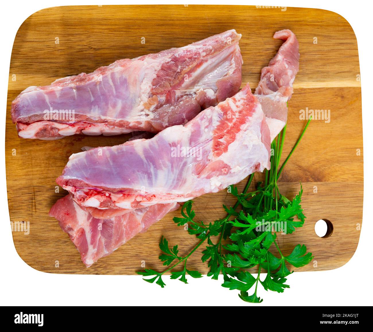 Raw meaty pork ribs slabs with greens on wooden cutting board Stock ...
