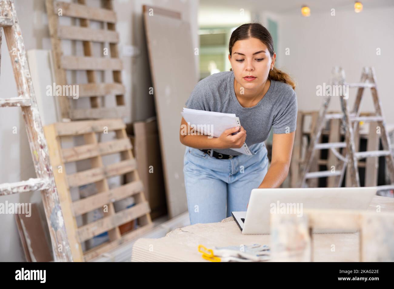 Female architect using laptop during repair works Stock Photo - Alamy