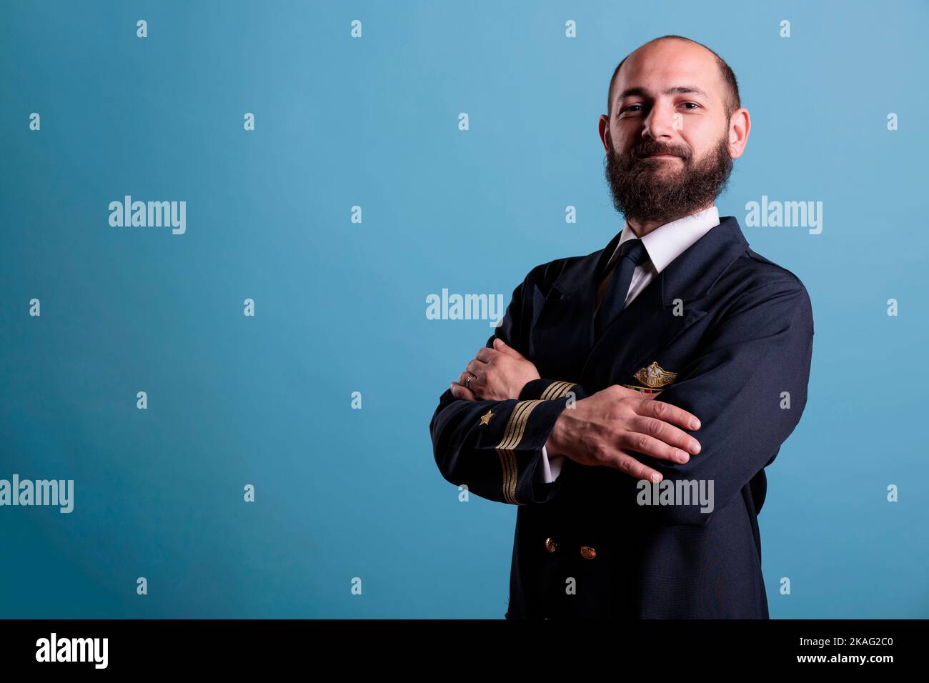 Airplane captain wearing uniform portrait standing with crossed arms ...