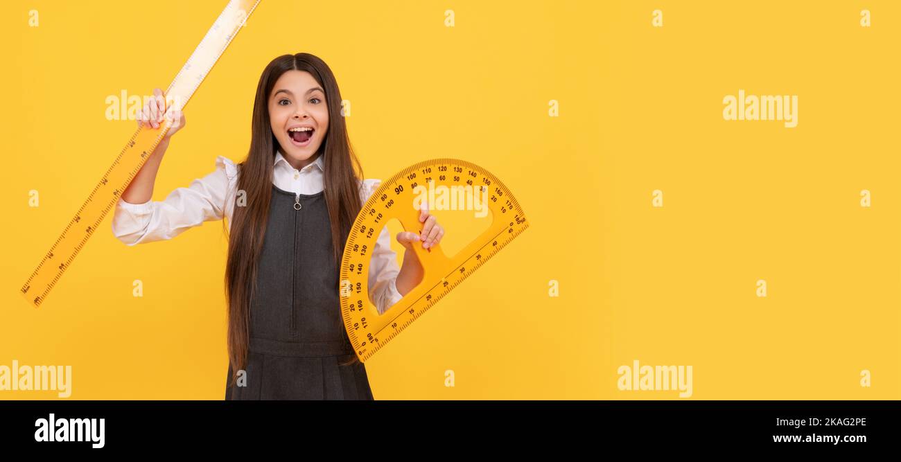 happy kid hold math protractor and ruler in school on yellow background ...