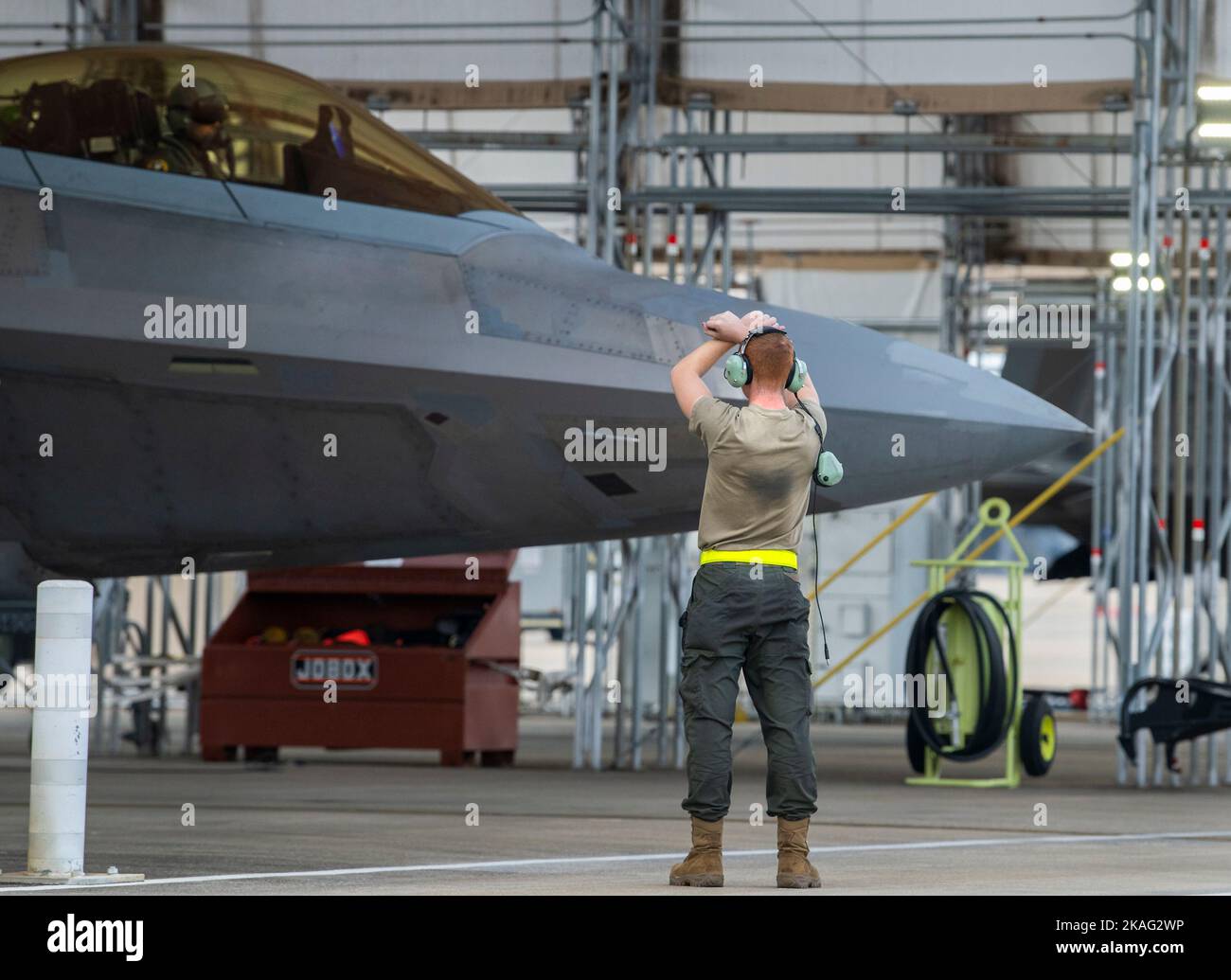 A 325th Fighter Wing maintainer prepares to marshal out an F-22A Raptor ...