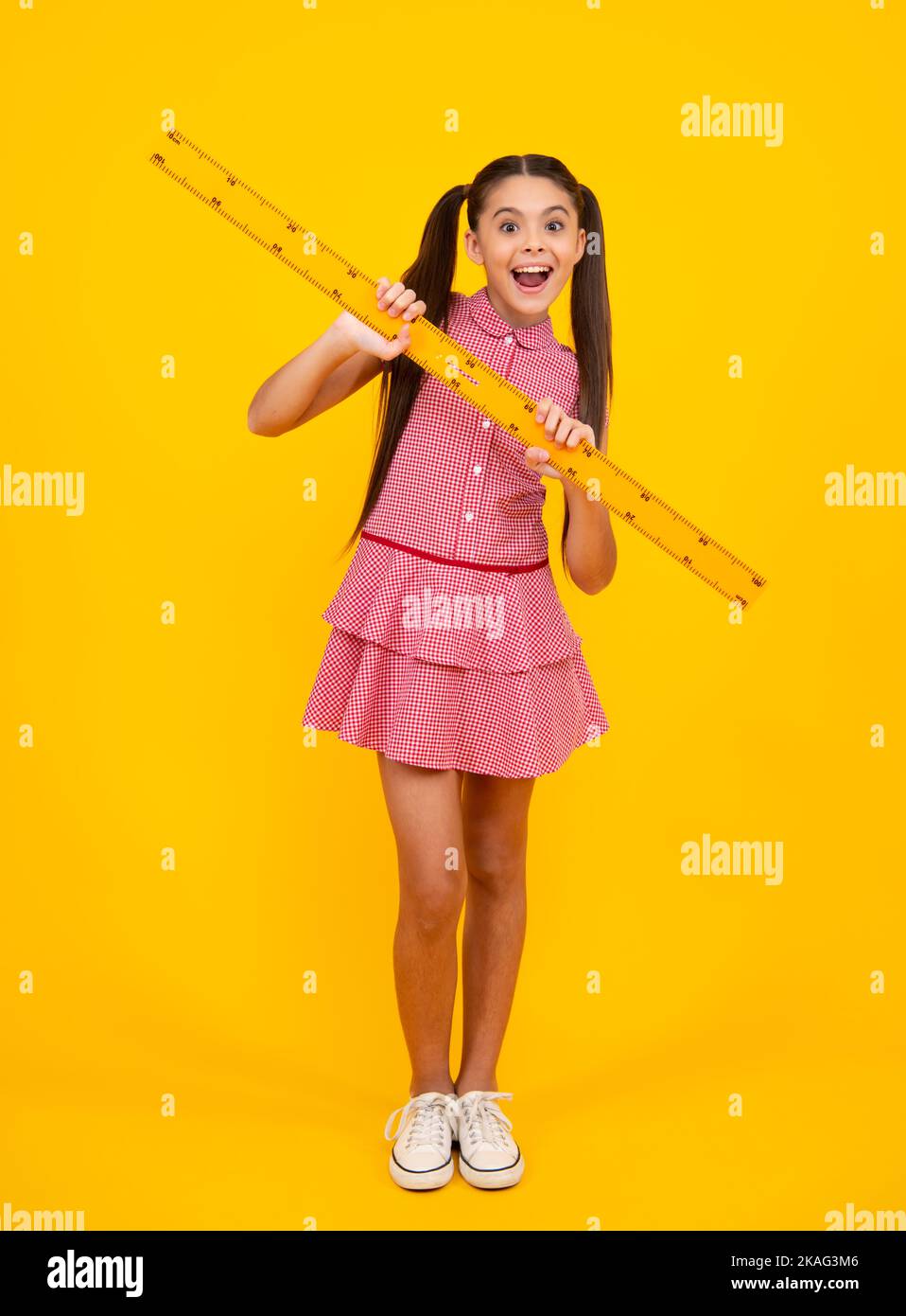 Amazed teenager. Teenager child school girl holding measure for ...