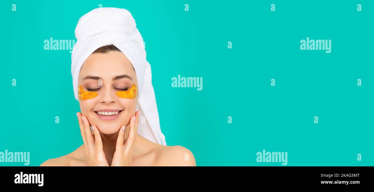 glad young lady has collagen golden eye patches on face with towel ...