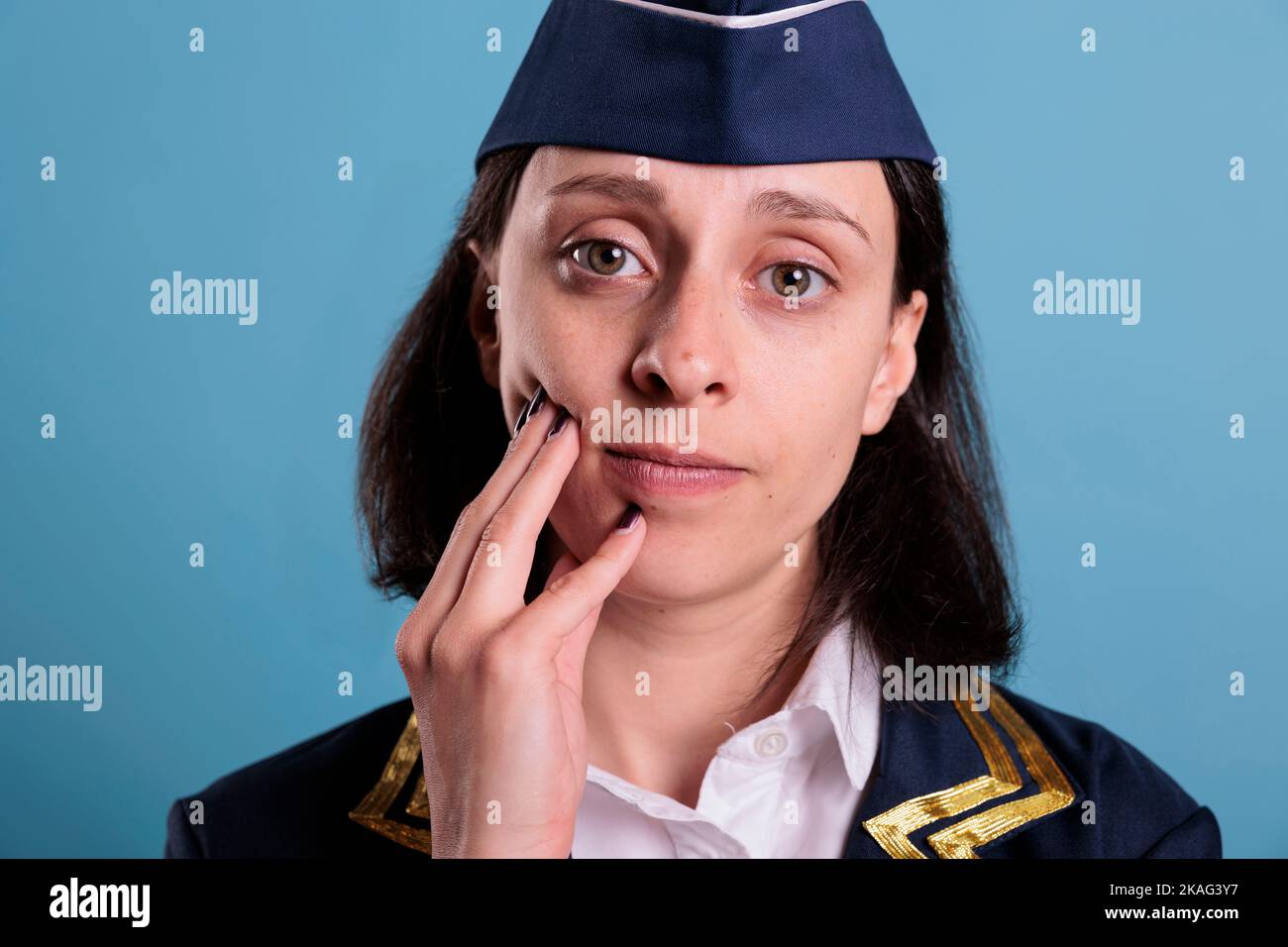 Flight attendant looking at camera with neutral calm facial expression ...