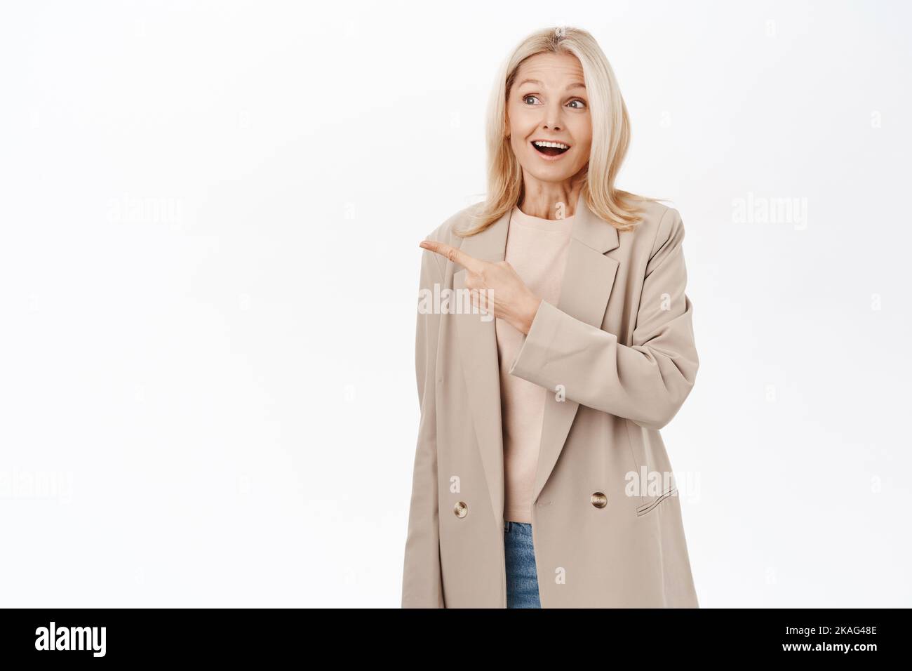 Surprised middle aged woman, blond lady 50 years old, pointing finger ...