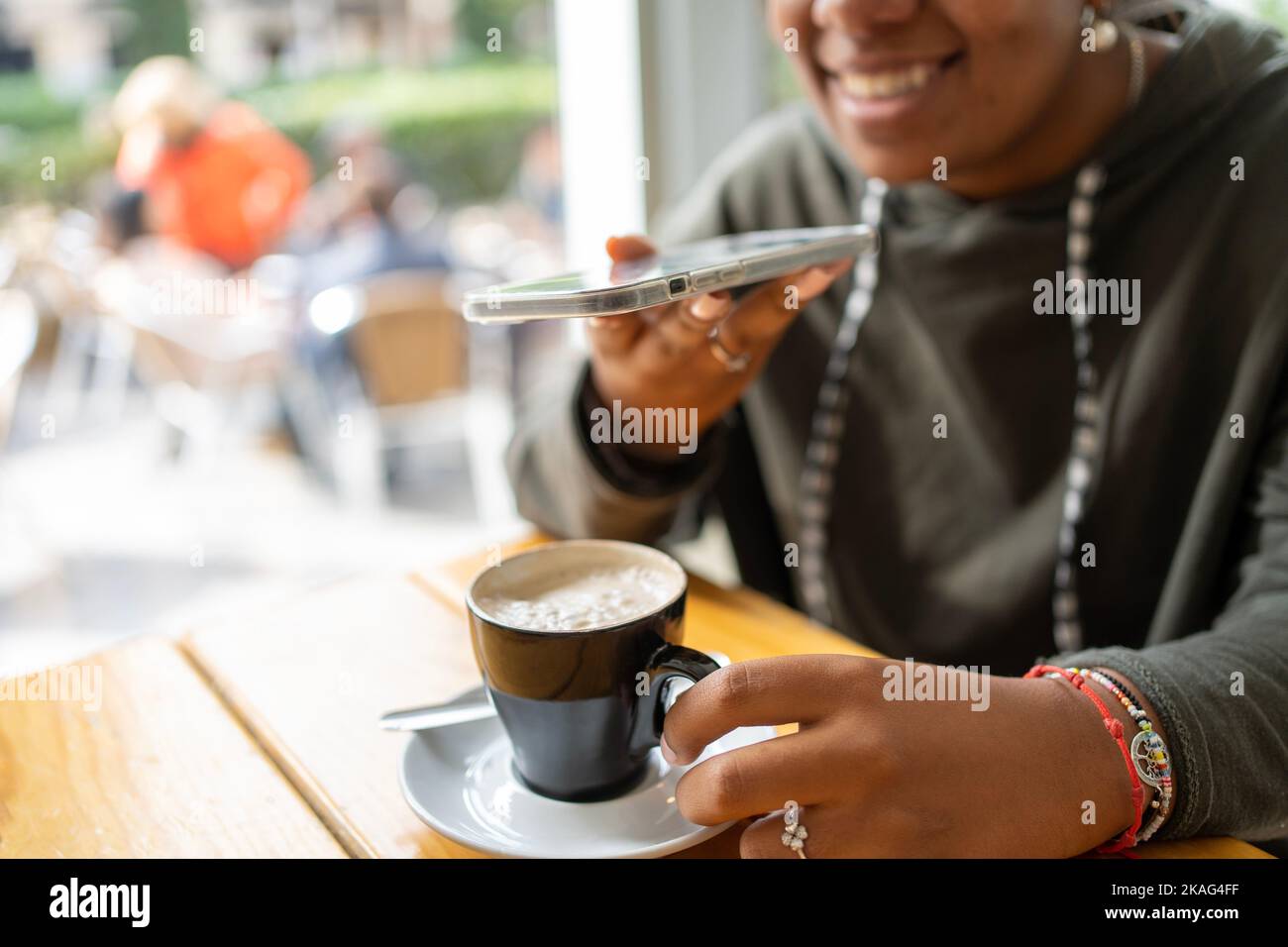 Young woman calling with cell telephone while sitting alone in coffee ...