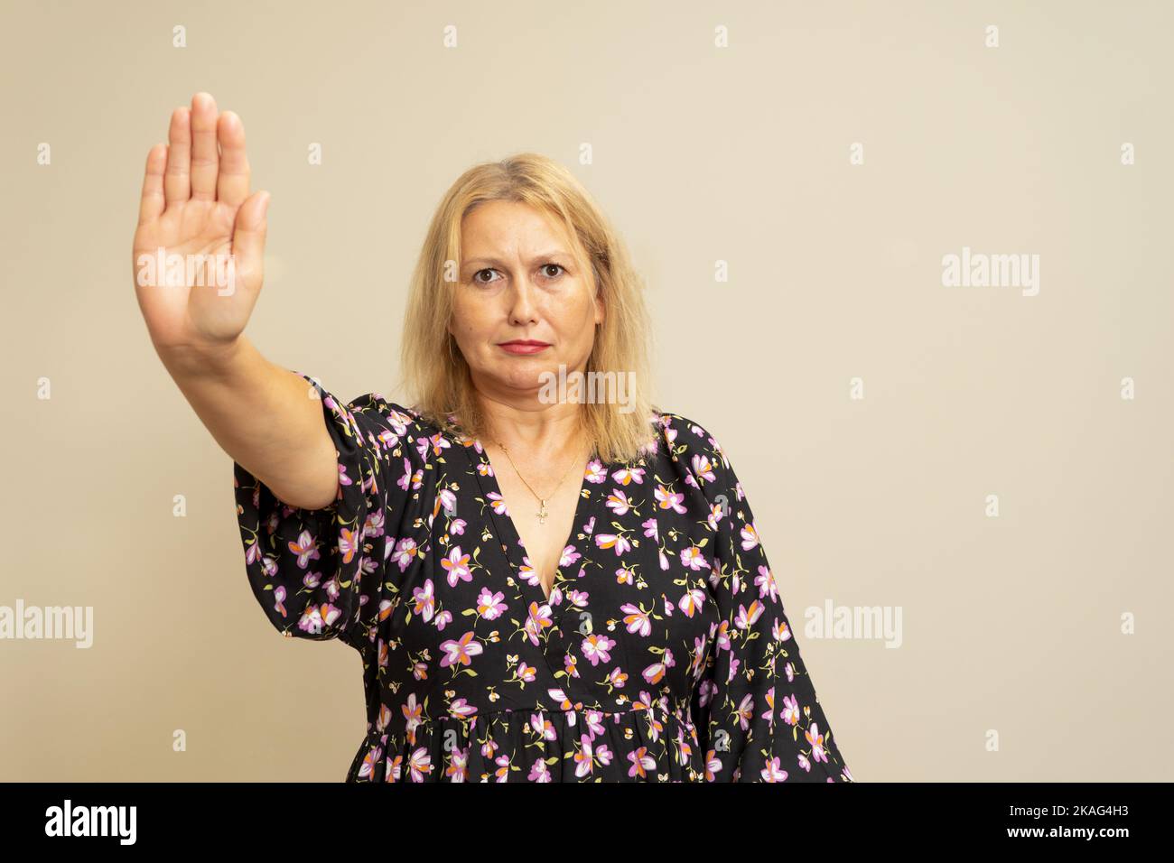 Portrait of attractive strict fair-haired woman showing palm stop sign ...