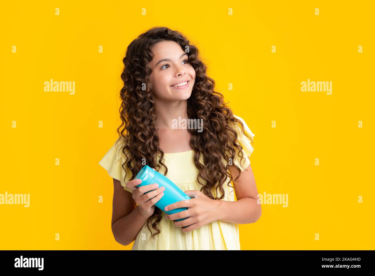 Happy portrait of child teen girl with shampoos conditioners and shower ...