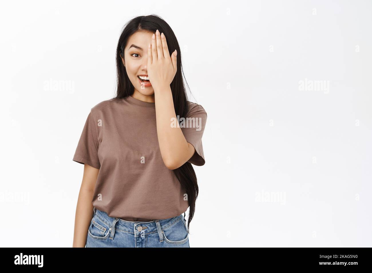 Portrait of young asian woman cover one side of face, looking with one ...