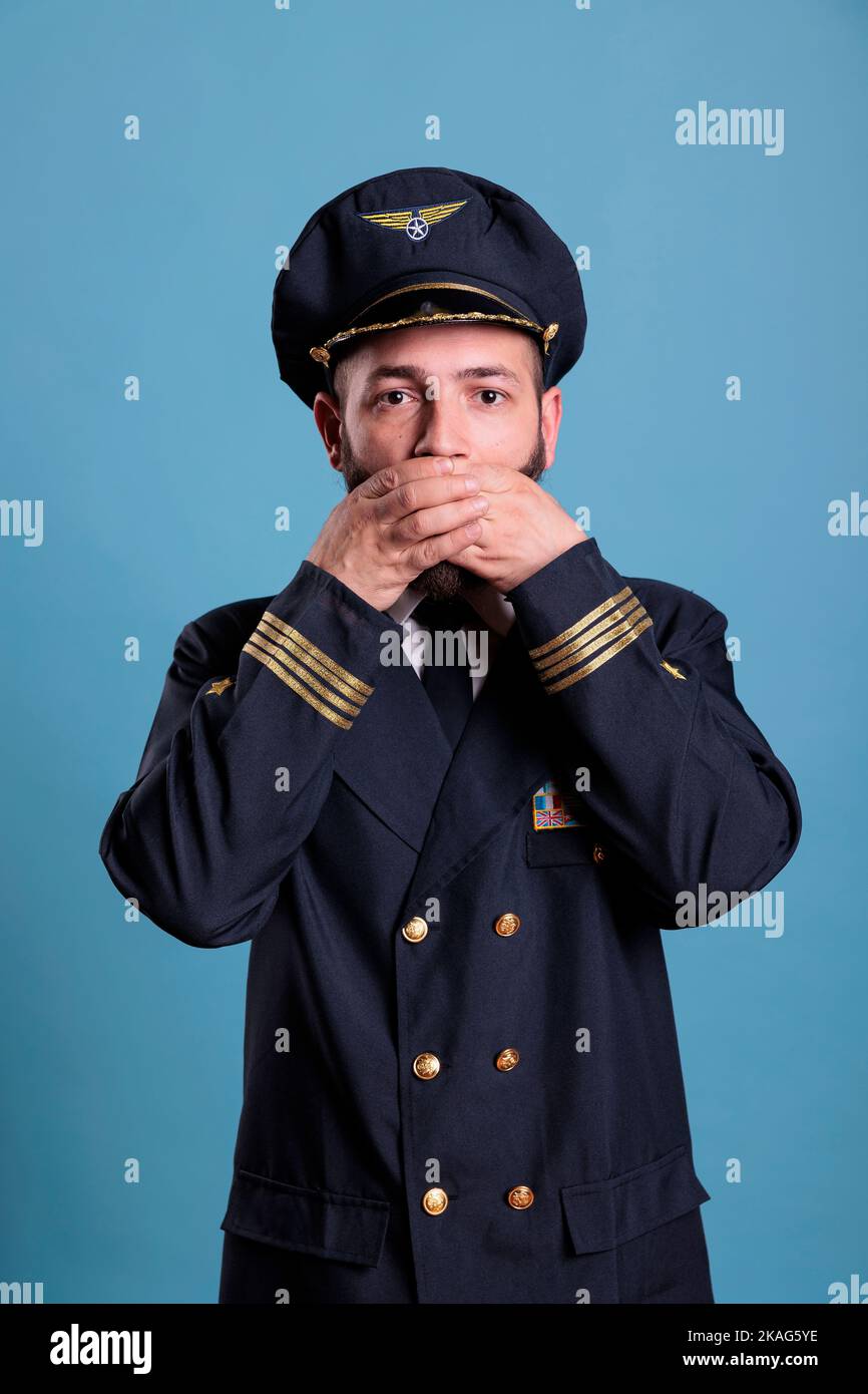 Airliner captain covering mouth with hands, showing speak no evil ...