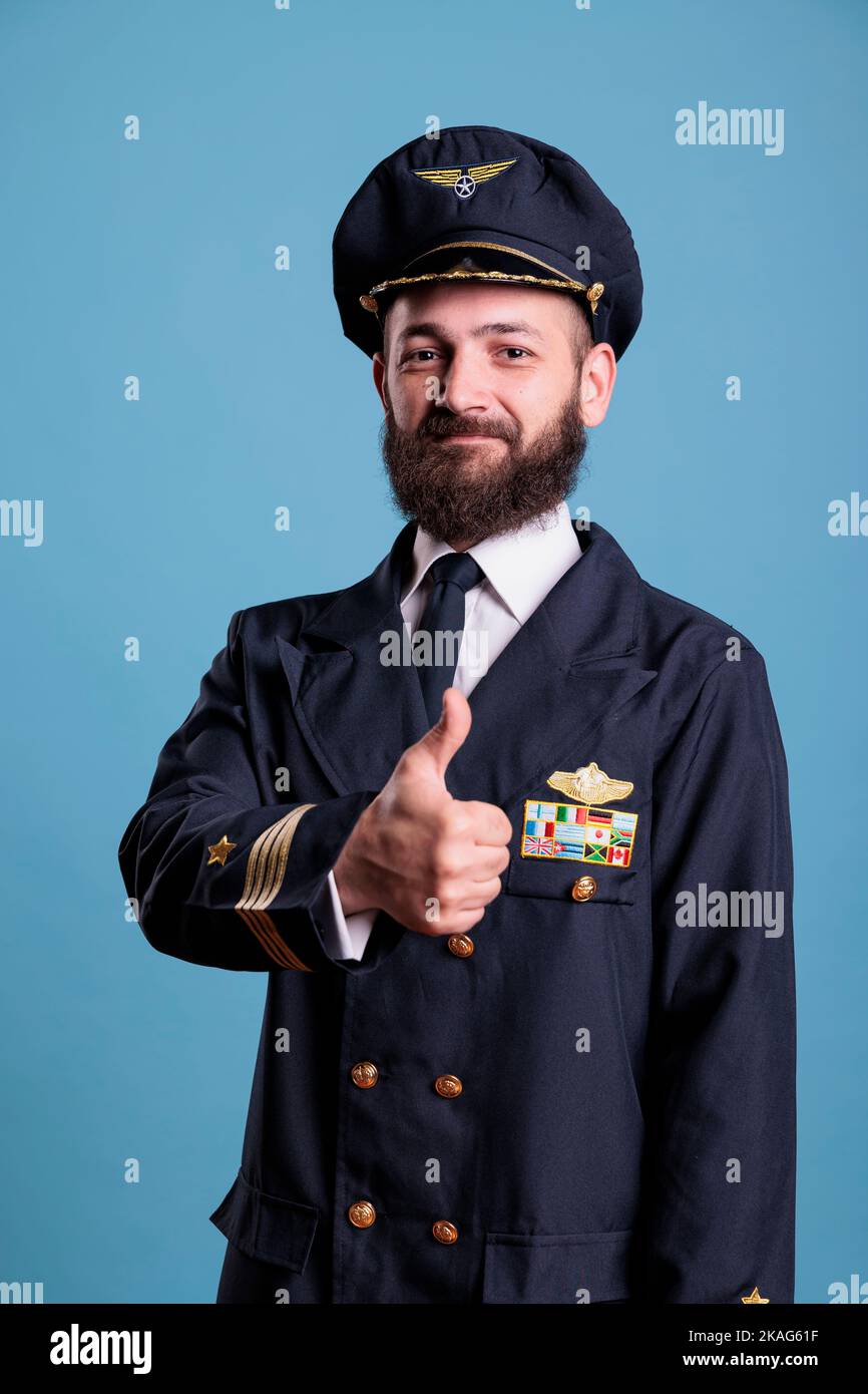 Smiling airplane aviator showing thumb up gesture wearing professional ...