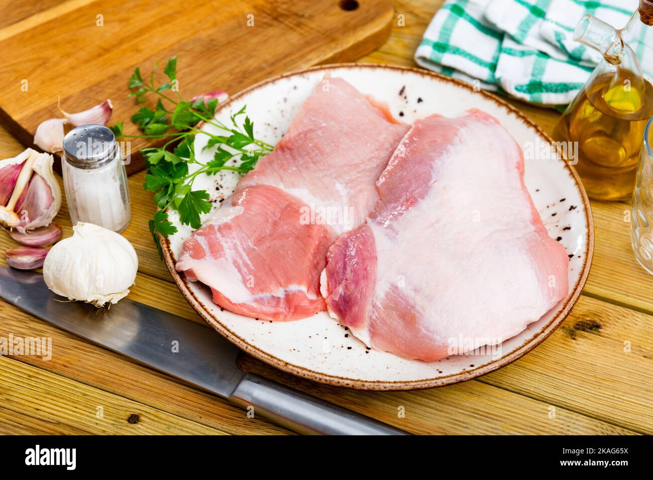 Raw pork secreto fillet and condiments prepared for roasting on plate ...
