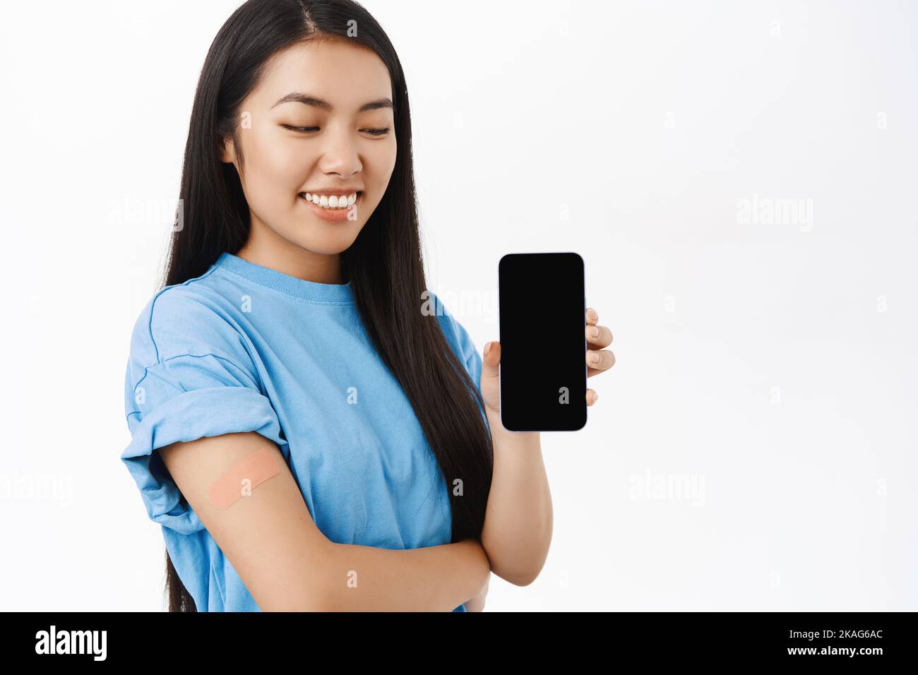 Smiling asian girl with band aid after coronavirus vaccine, shows ...