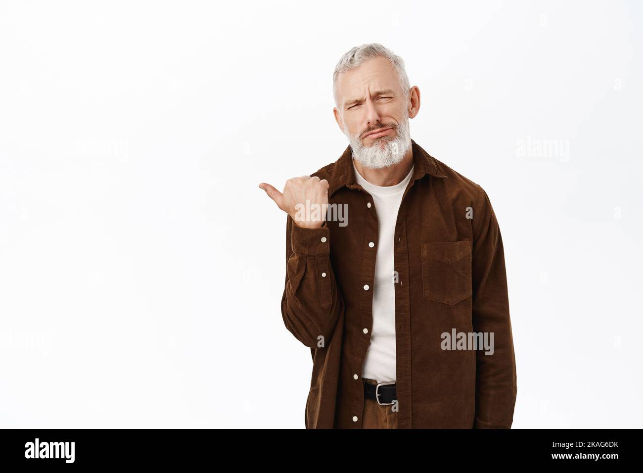 Sad and gloomy old man, senior male model pointing finger left and ...