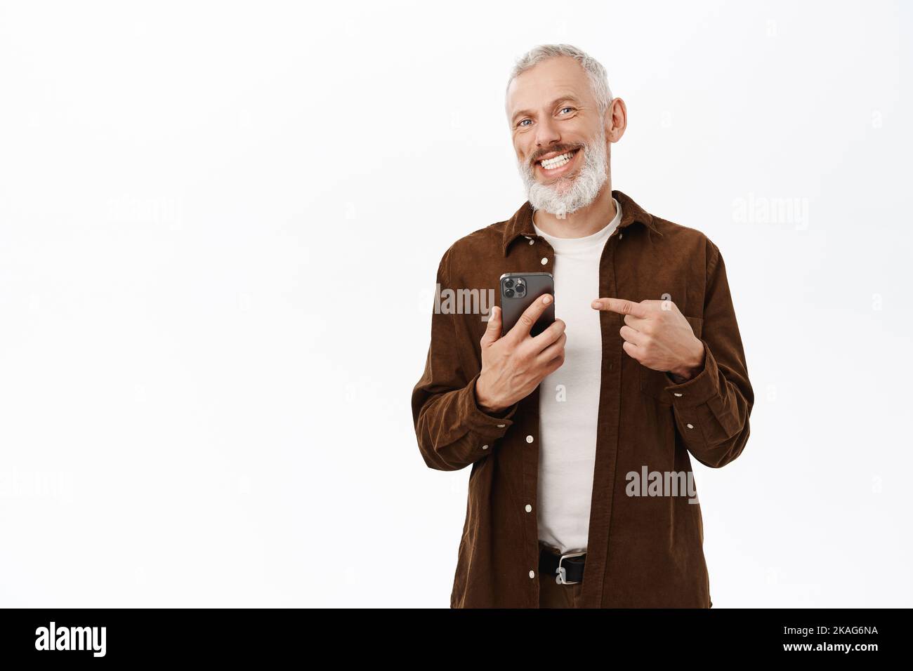 Handsome old man, dad with grey hair, pointing finger at mobile phone ...