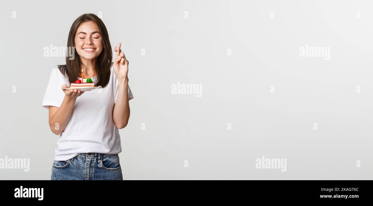 Hopeful and happy smiling birthday girl cross fingers and making wish ...