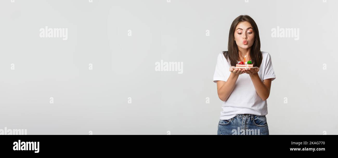 Excited and dreamy cute birthday girl making wish on b-day cake ...