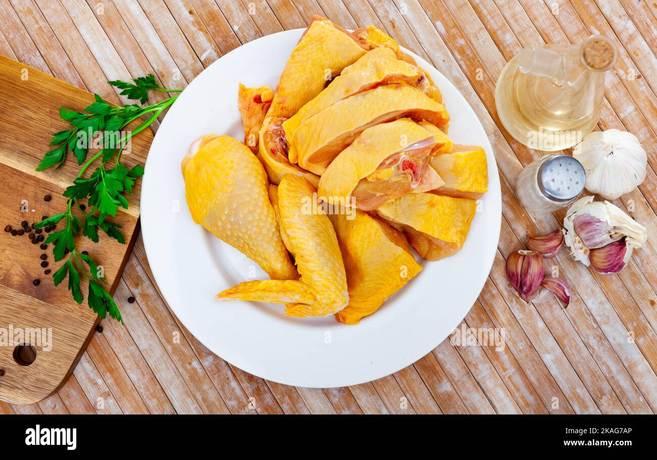 Raw chicken with condiments on kitchen table Stock Photo - Alamy