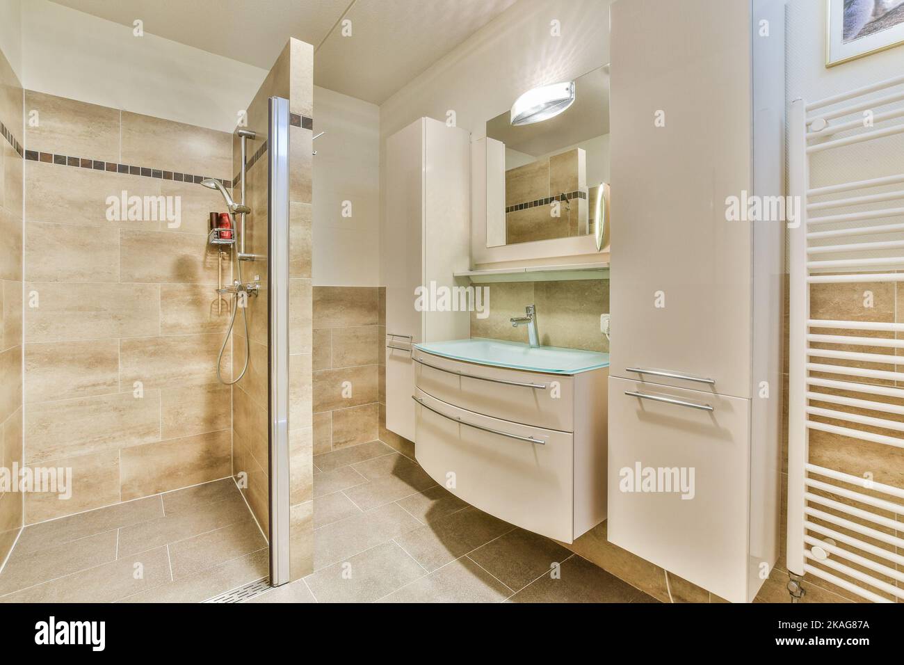 Bathroom with white tiled walls and open shower near sink base cabinet ...