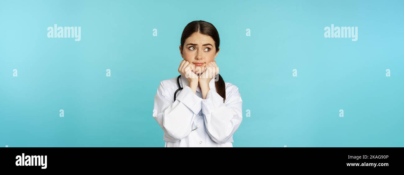 Scared and worried woman doctor in white coat, looking anxious and ...