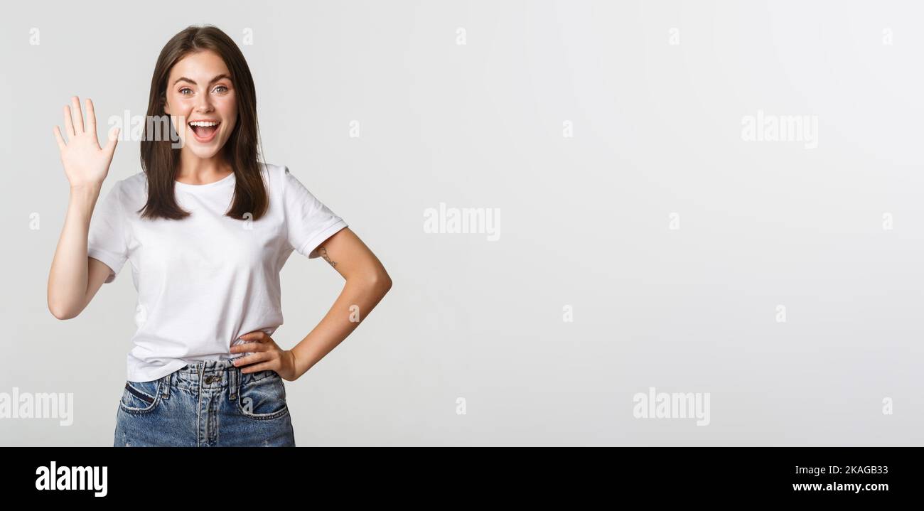 Friendly smiling girl waving hand to say hi, greeting someone Stock ...