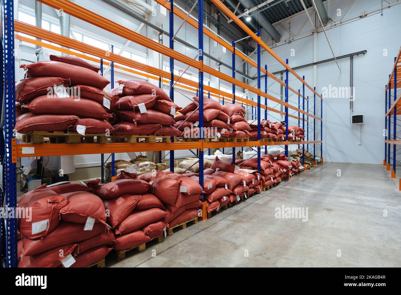 Bags with production on shelves in warehouse. Bags with coffee beans or ...
