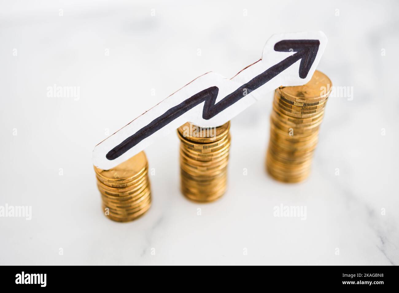 growing stacks of coins with arrow pointing upward, metaphor of ...
