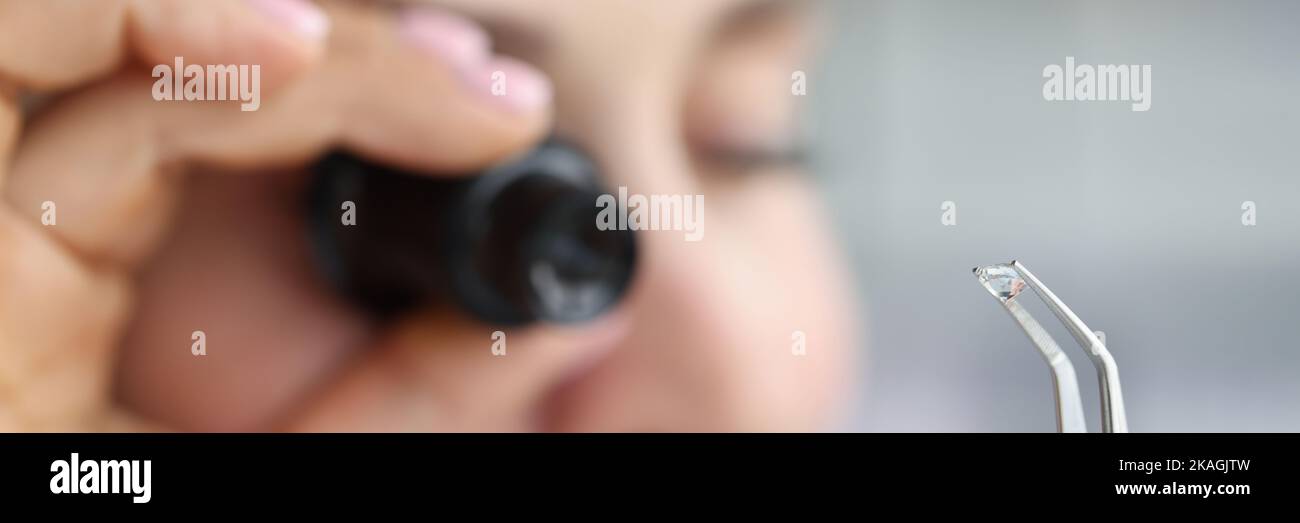 Jeweller examine polished diamond through magnifying glass, diamond ...