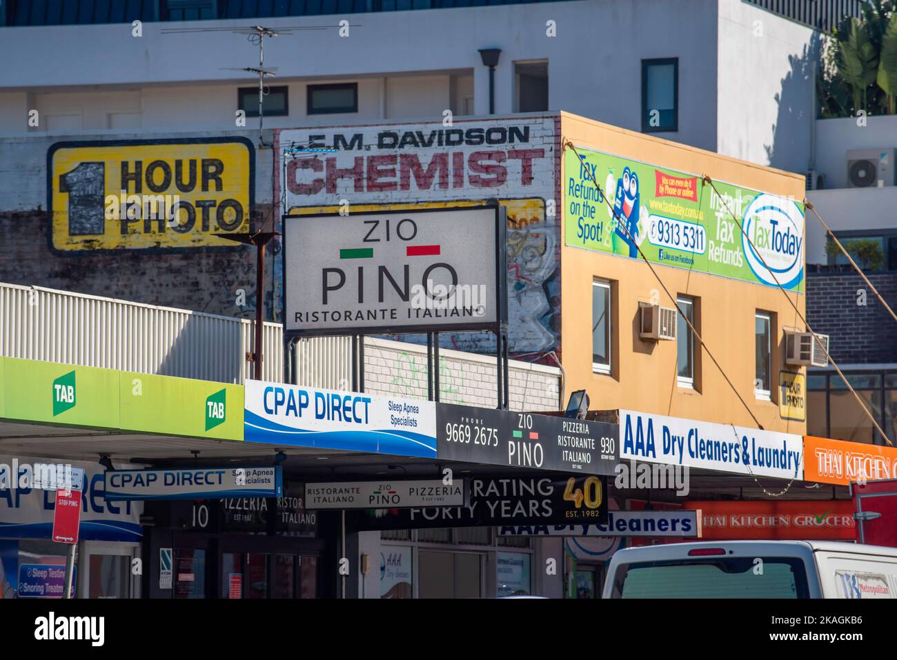 A sea of signs advertising shops and a chemist sit above the retail ...