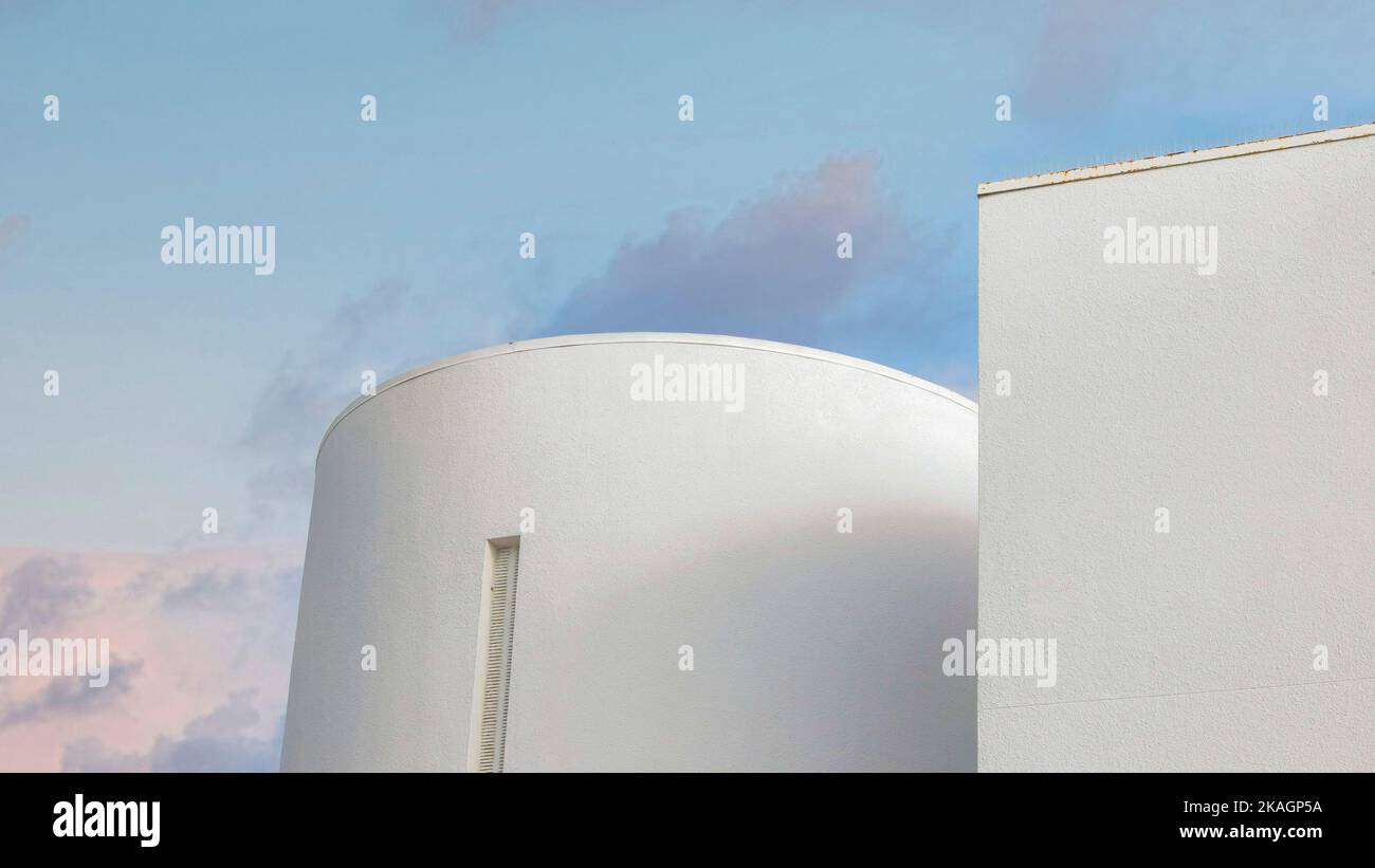 Panorama Puffy clouds at sunset White cylinder building in a low angle ...