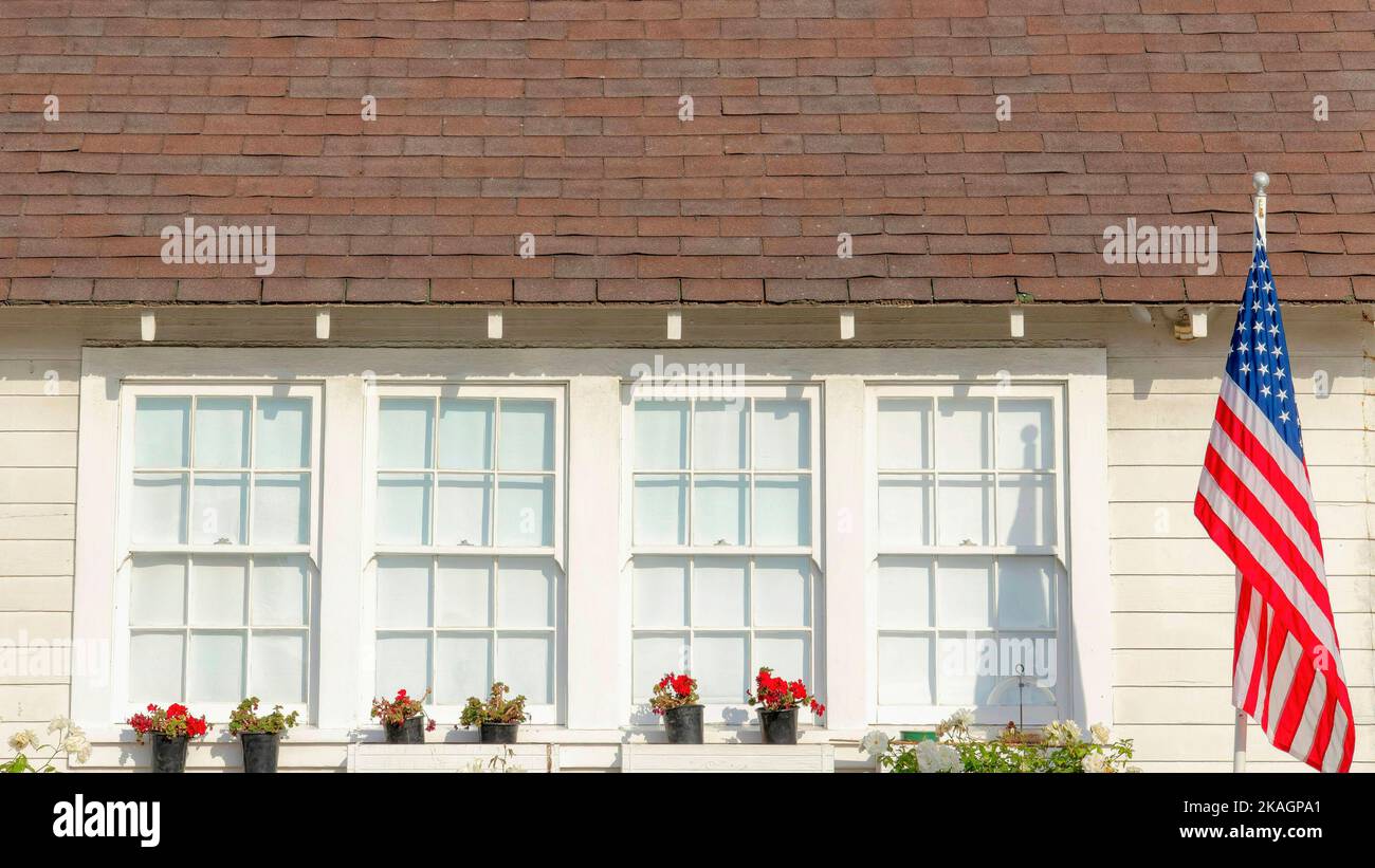 Panorama White puffy clouds Small traditional gable house with USA flag ...