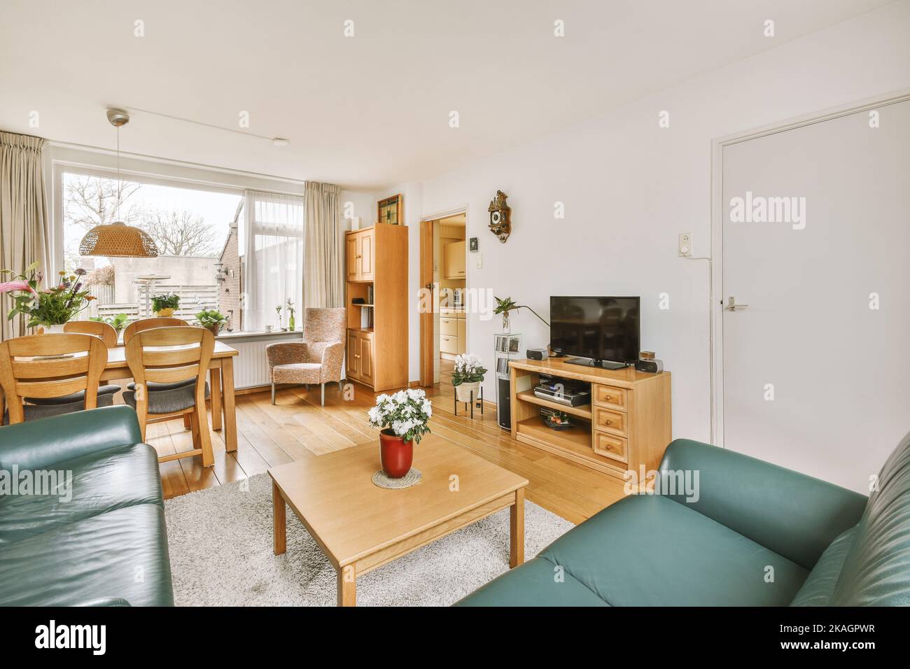 Couches and table located near TV against dining area of spacious room ...