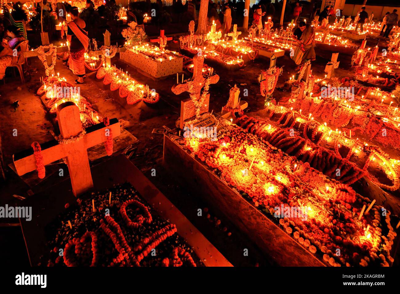 Graves seen well decorated with flowers and lit candles during All ...