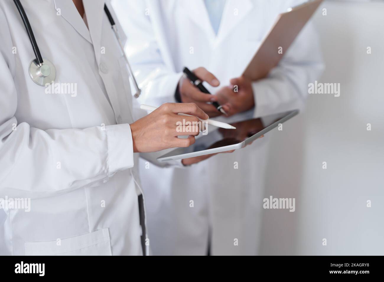 Portrait of an Asian female doctor and male doctor using a tablet to ...