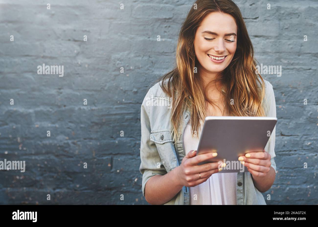 Keeping tabs on whats new and now. a young woman standing outdoors and ...