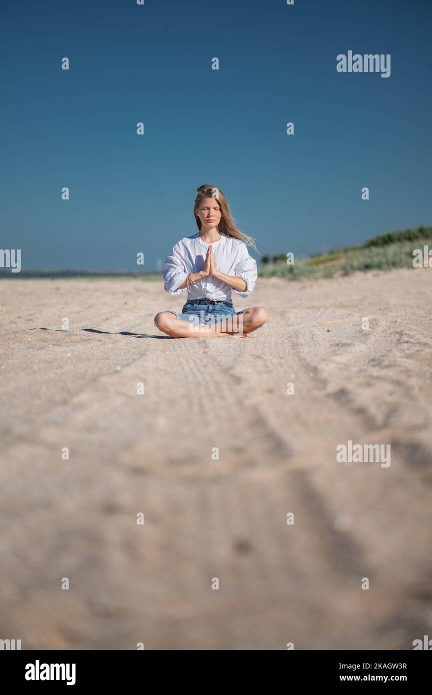 Girl practice meditation on the beach. With space for text or design ...