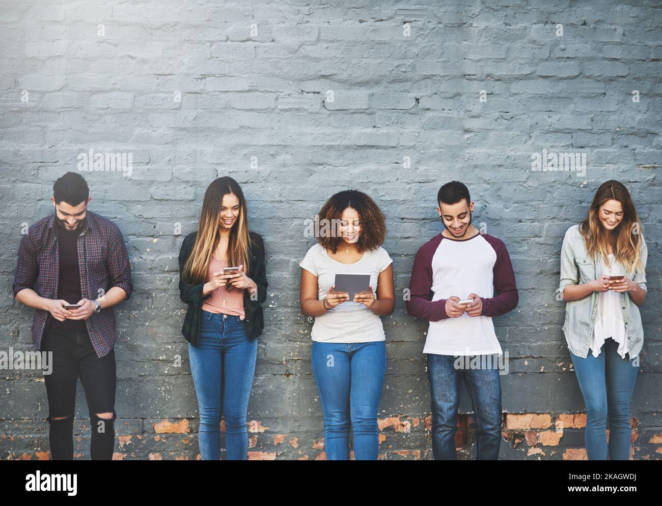 Technology fans. a group of young people using their wireless devices ...