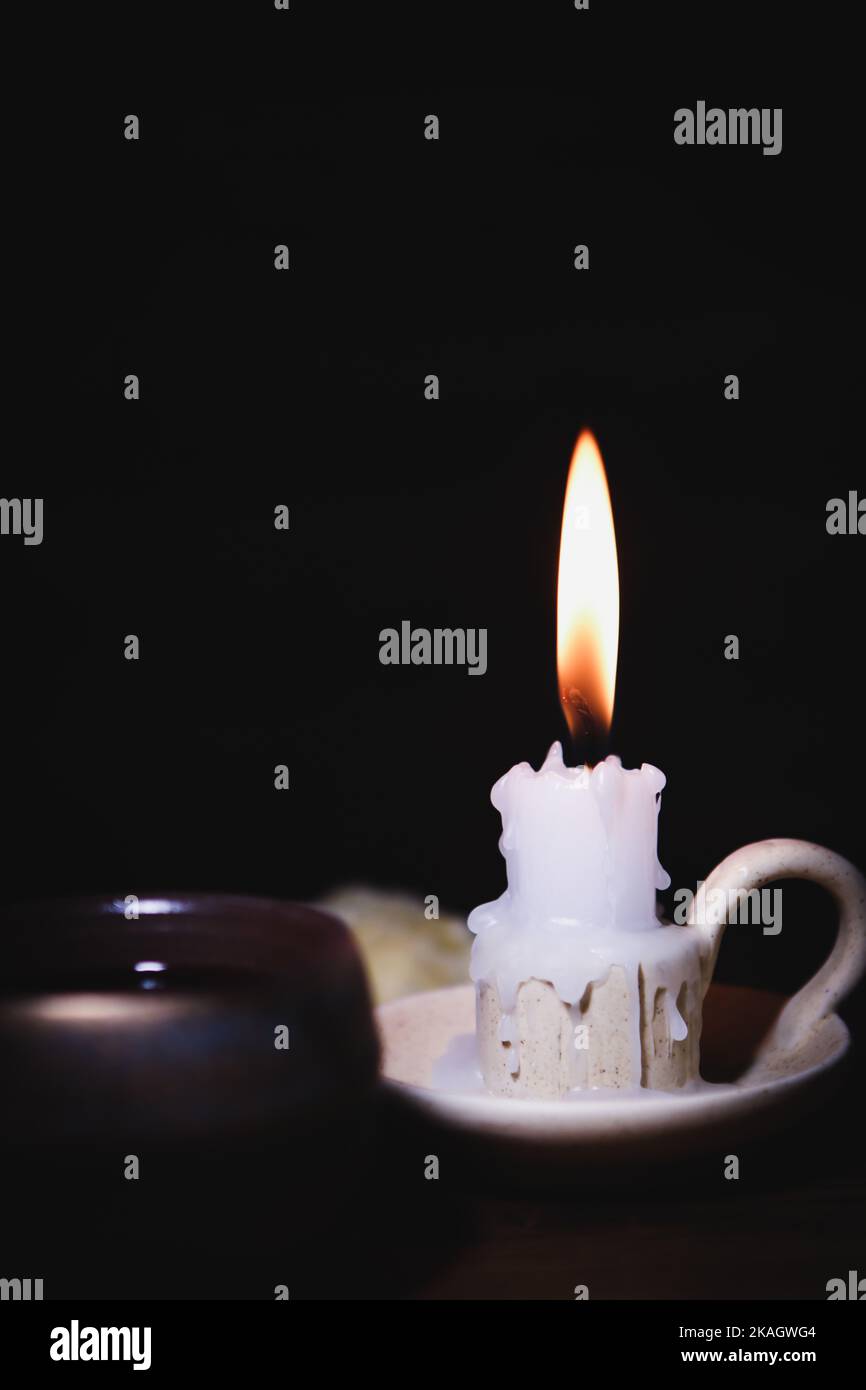 The brightly burning candle on the candlestick, the holy bible, and the ...