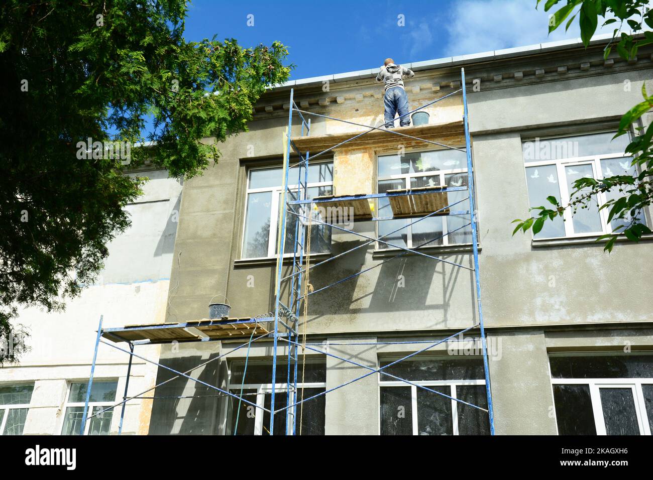Rendering, painting wall, applying stucco, and plastering the facade of ...