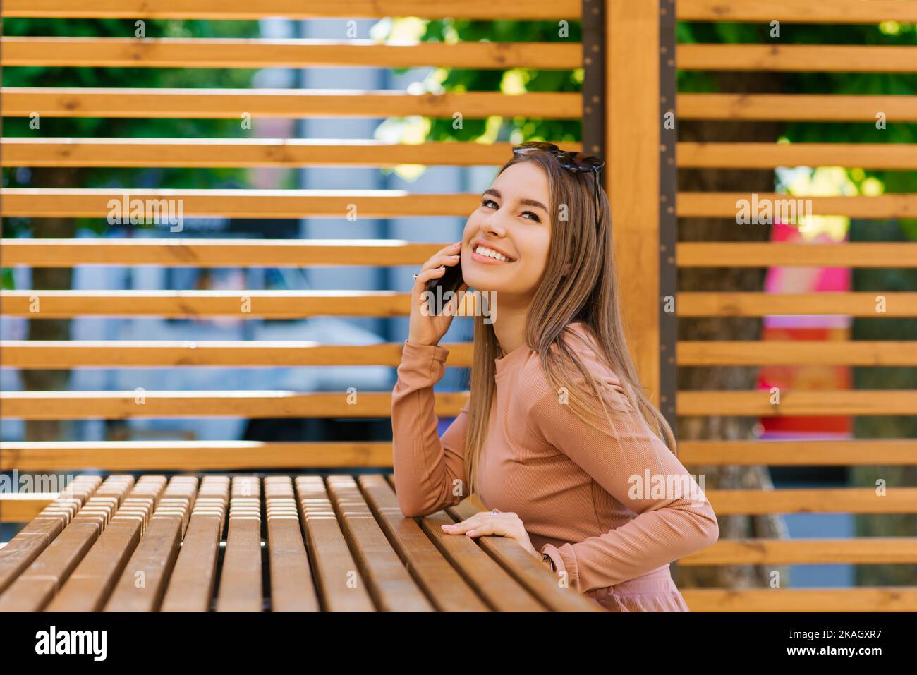 Young beautiful woman uses a mobile phone in a modern eco-friendly cafe ...