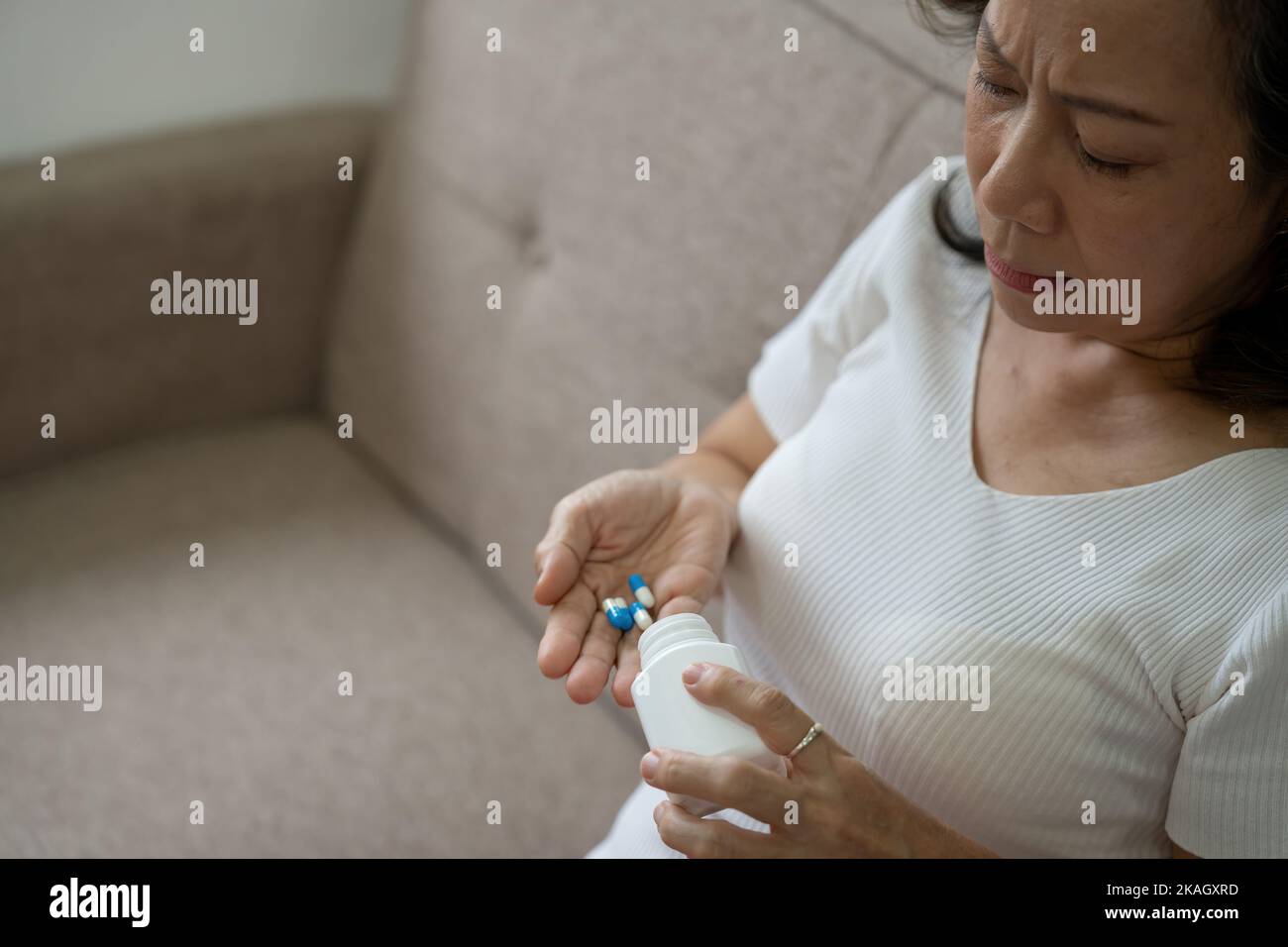 Elderly sick ill woman hold pills on hand pouring capsules from ...