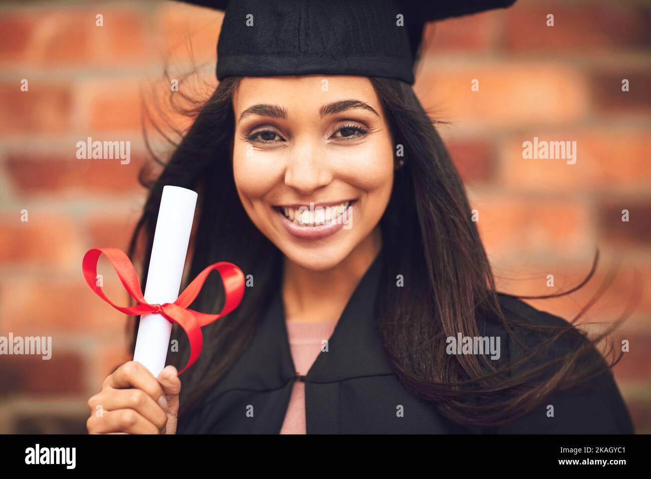 She looks to the future and smiles. a happy young graduate standing ...